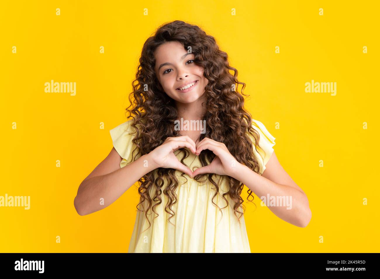 Child hands making sign heart by fingers. Happy teenager portrait ...