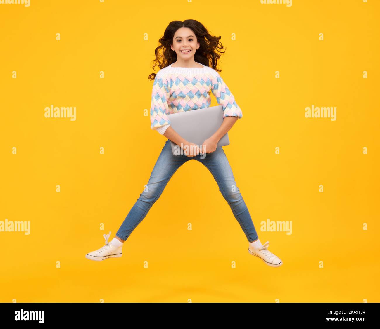Young student school girl, studying with laptop computer. Run and jump ...