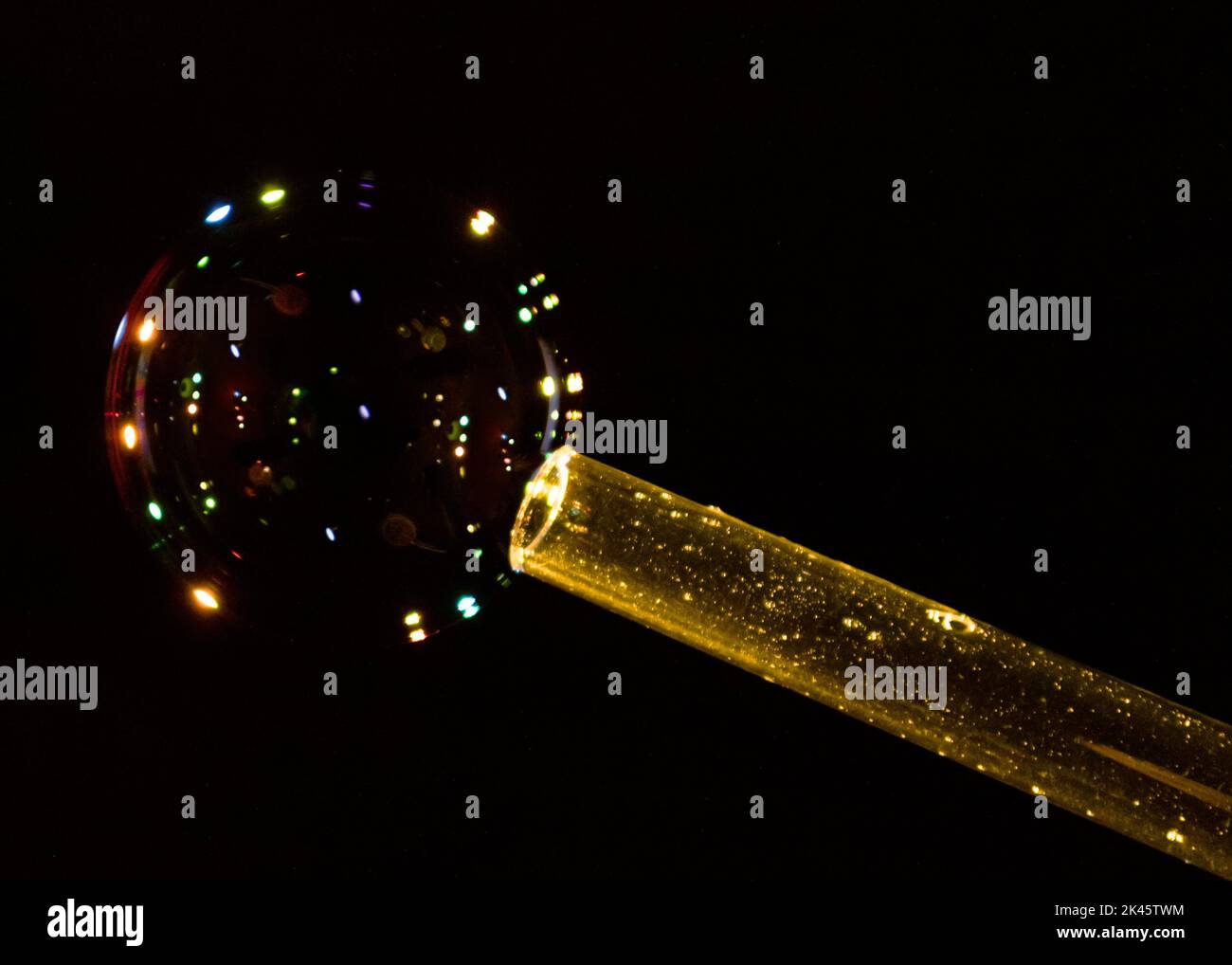 colored lights reflected in soap bubble created through a transparent ...