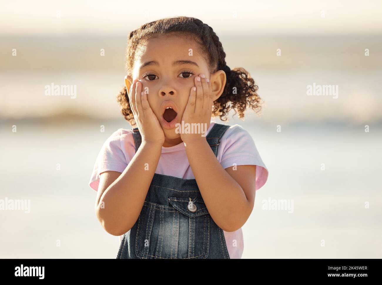 Wow, children and hands on the face of a girl on the beach looking ...