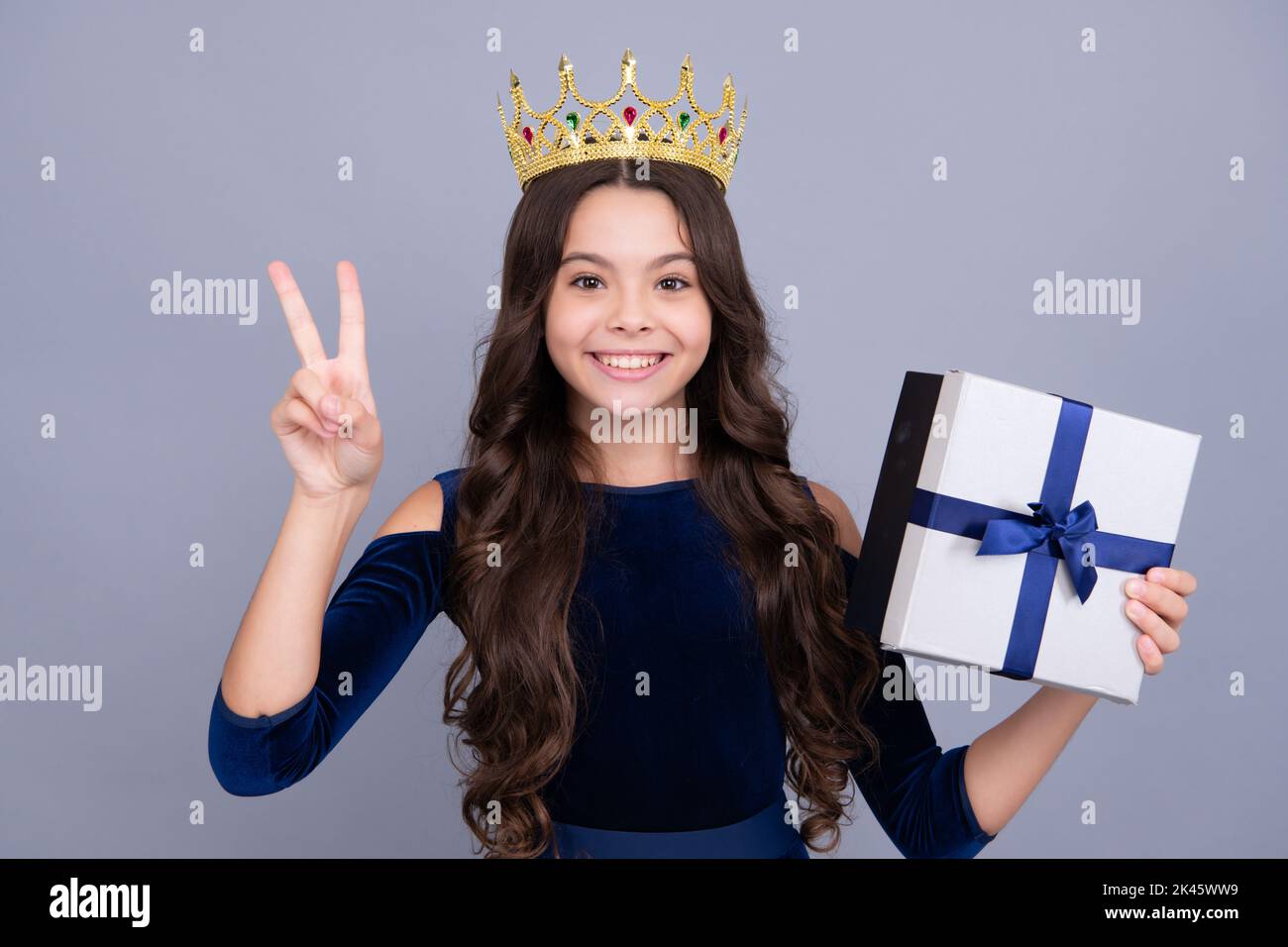 Teenager kid with present box. Teen girl princess in crown giving ...