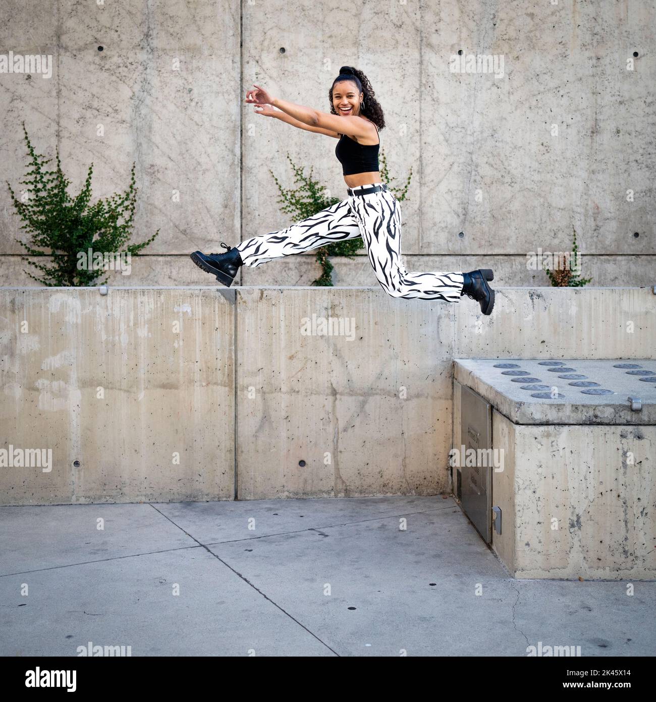 Sequence of Shots of Happy Young Black Woman Jumping Off a Walkway ...
