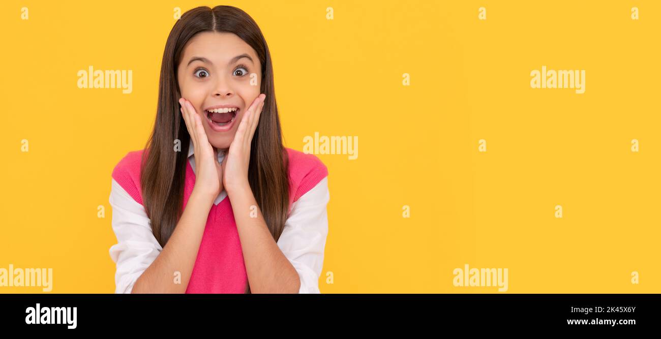 surprised teen school girl smiling with long hair on yellow background ...