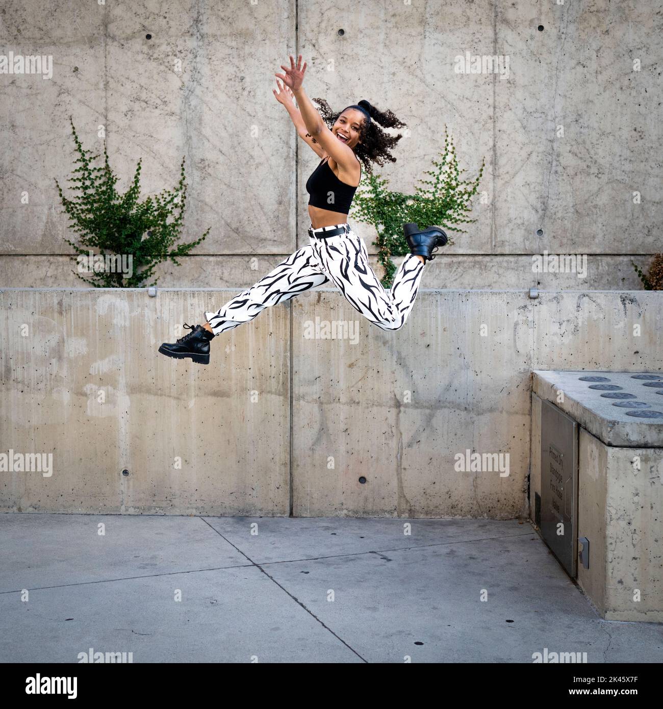 Sequence of Shots of Happy Young Black Woman Jumping Off a Walkway ...