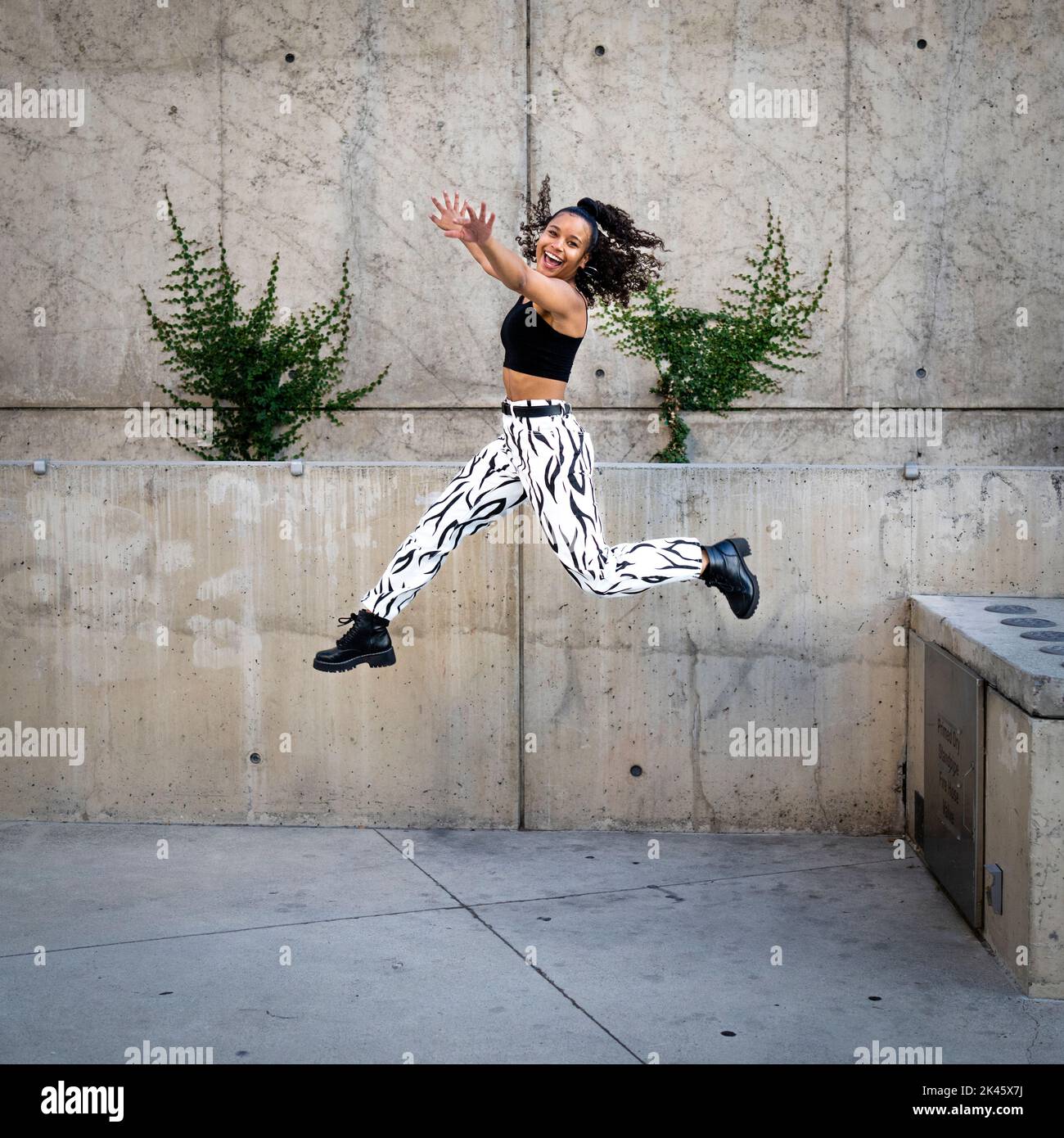 Sequence of Shots of Happy Young Black Woman Jumping Off a Walkway ...