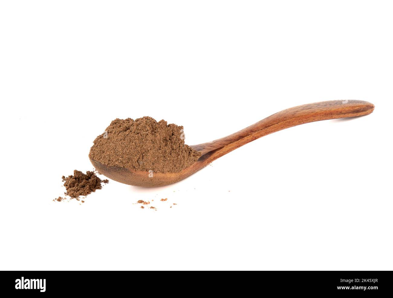 Ground cinnamon on a wooden spoon over white background. Copy space ...