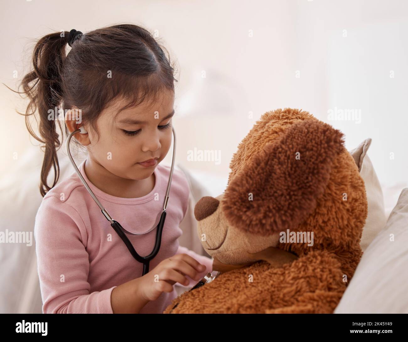 Stethoscope, girl and a teddy bear playing future doctor game showing ...