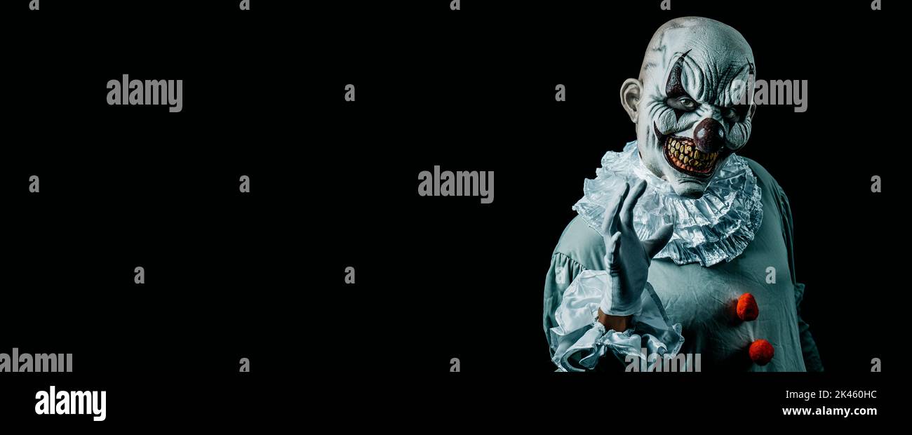 a creepy evil clown, in a gray costume with a white ruff around his ...