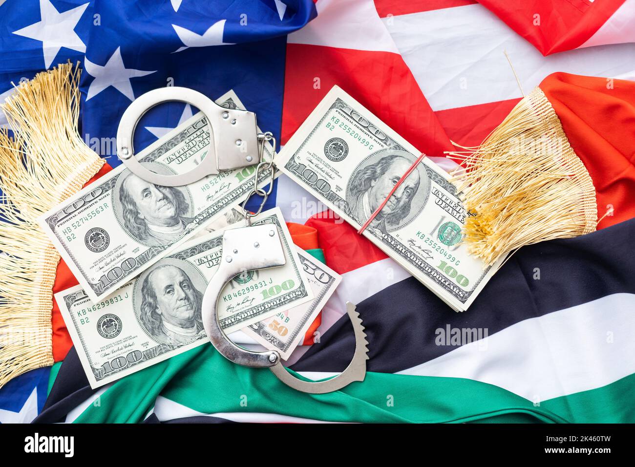 metal handcuff, american dollars cash over flag of USA and UAE flags ...
