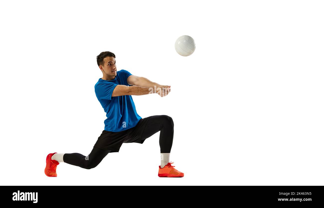 Studio shot of young man, volleyball player playing volleyball isolated ...