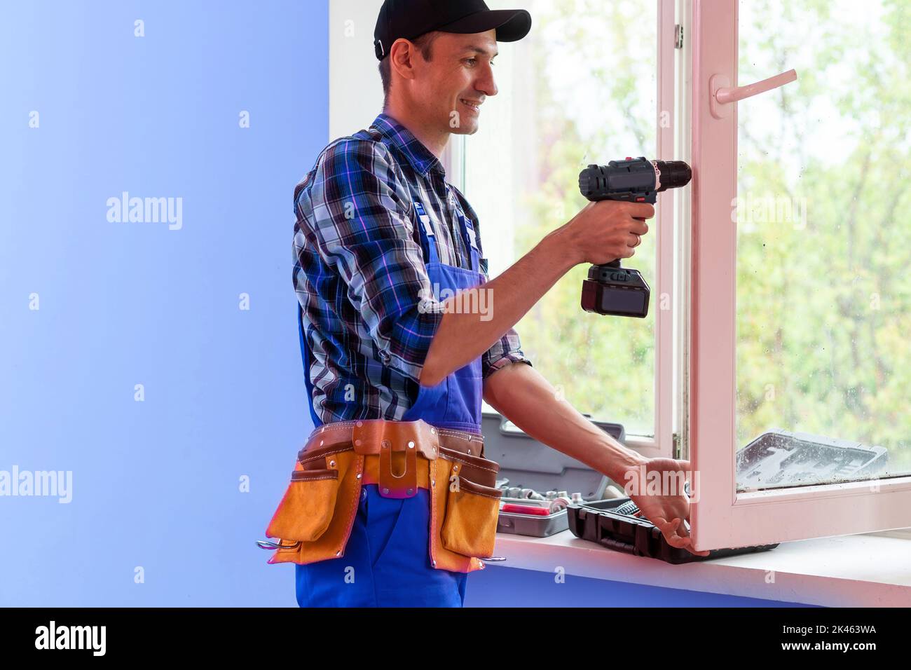 Construction worker installing window in house Stock Photo - Alamy