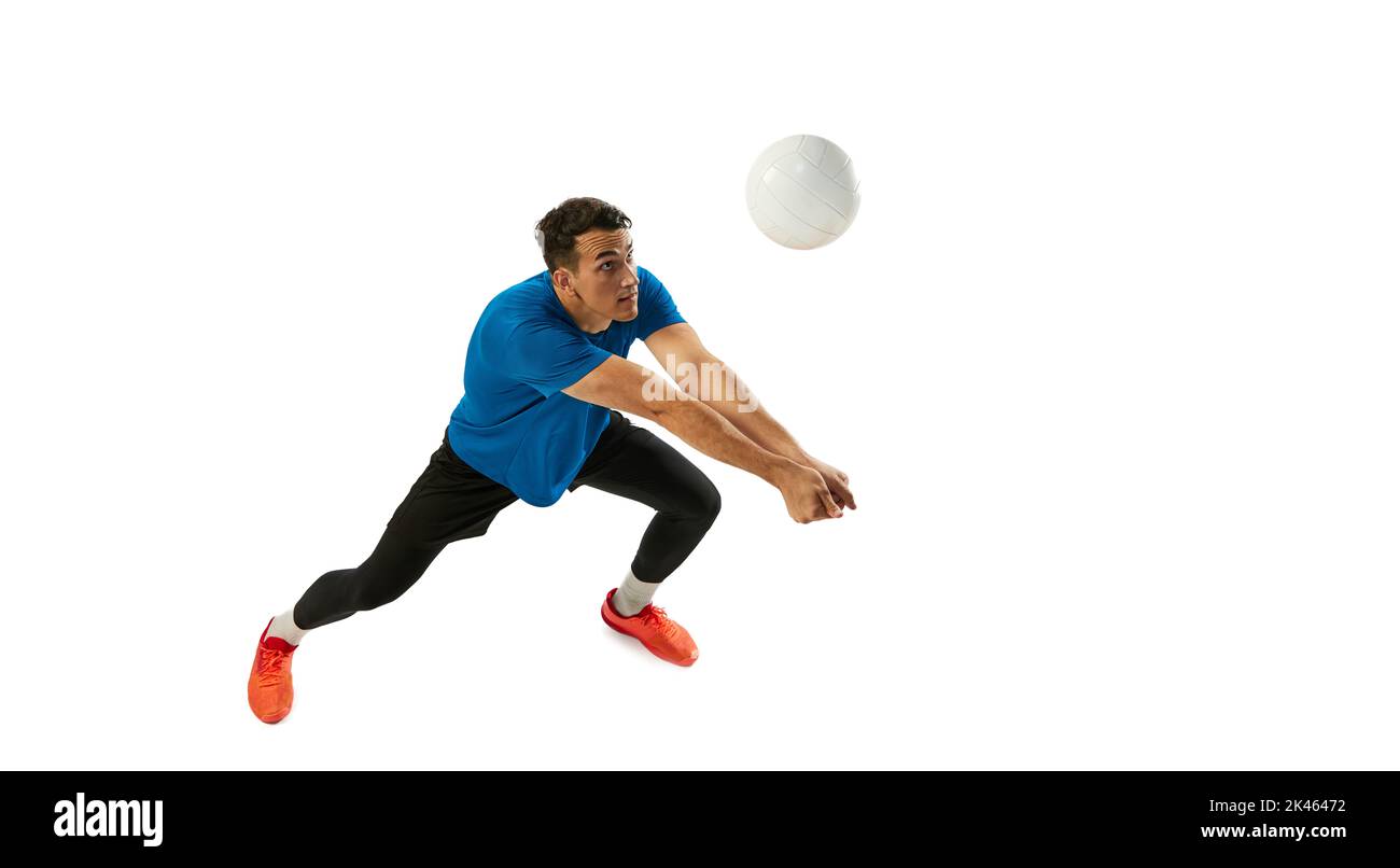 Dynamic portrait of male volleyball player training with ball isolated ...