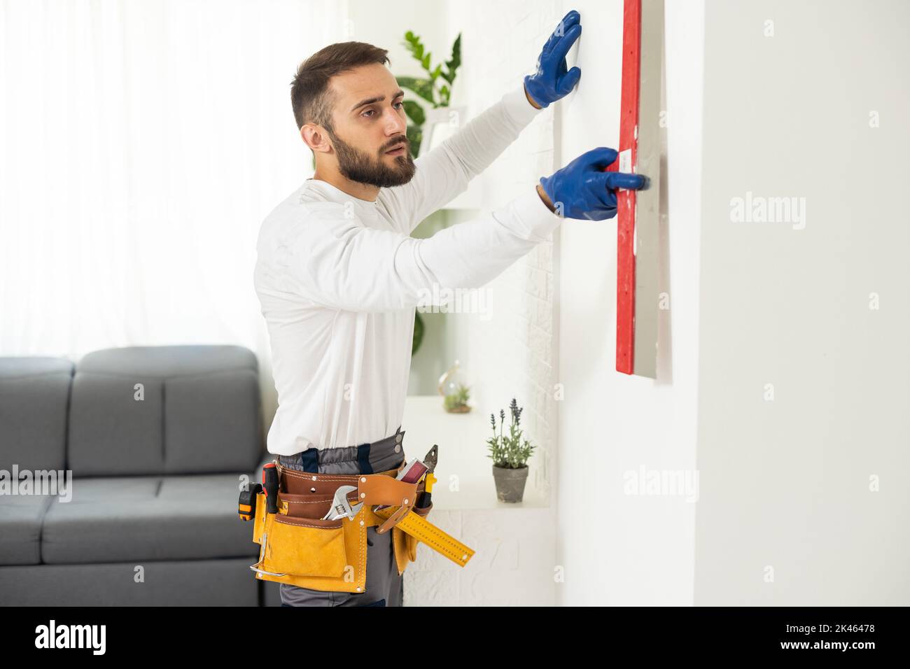man plasterer construction worker at work, takes plaster from bucket ...