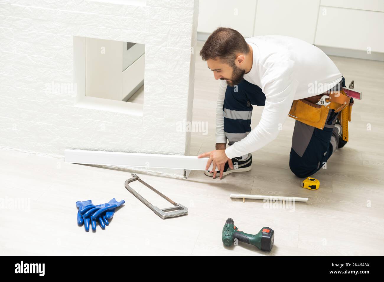 The craftsman measures the length of the plinth for cutting, installing ...