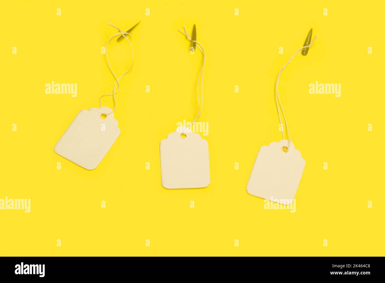 Three blank white carton labels on a yellow background with copy space ...