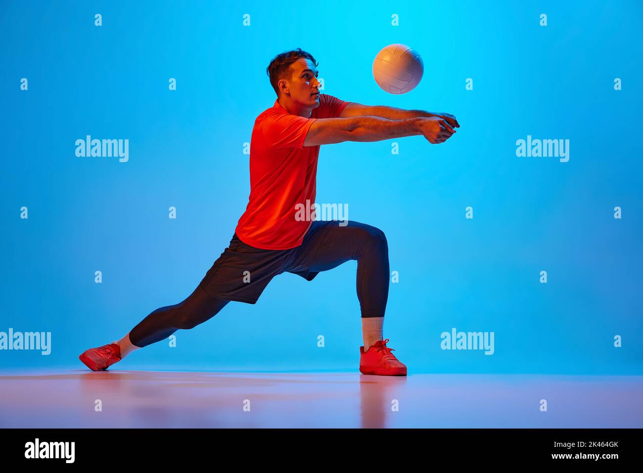 Receiving ball. Volleyball player training with ball isolated on blue ...