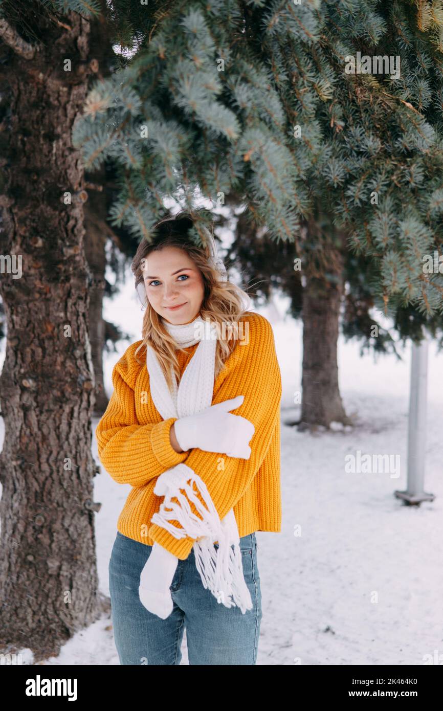 Teen blonde in a yellow sweater outside in winter. A teenage girl on a ...