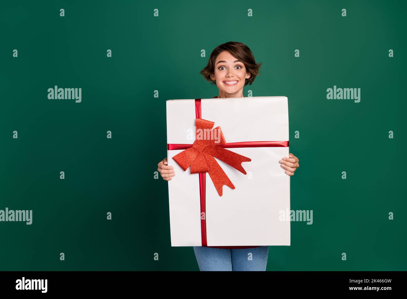 Photo of shiny excited girl dressed ugly print pullover rising huge bow ...