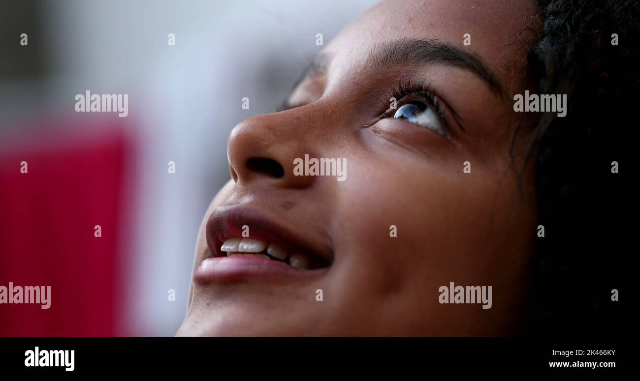 Hispanic black girl child opening eyes to sky smiling face close-up ...