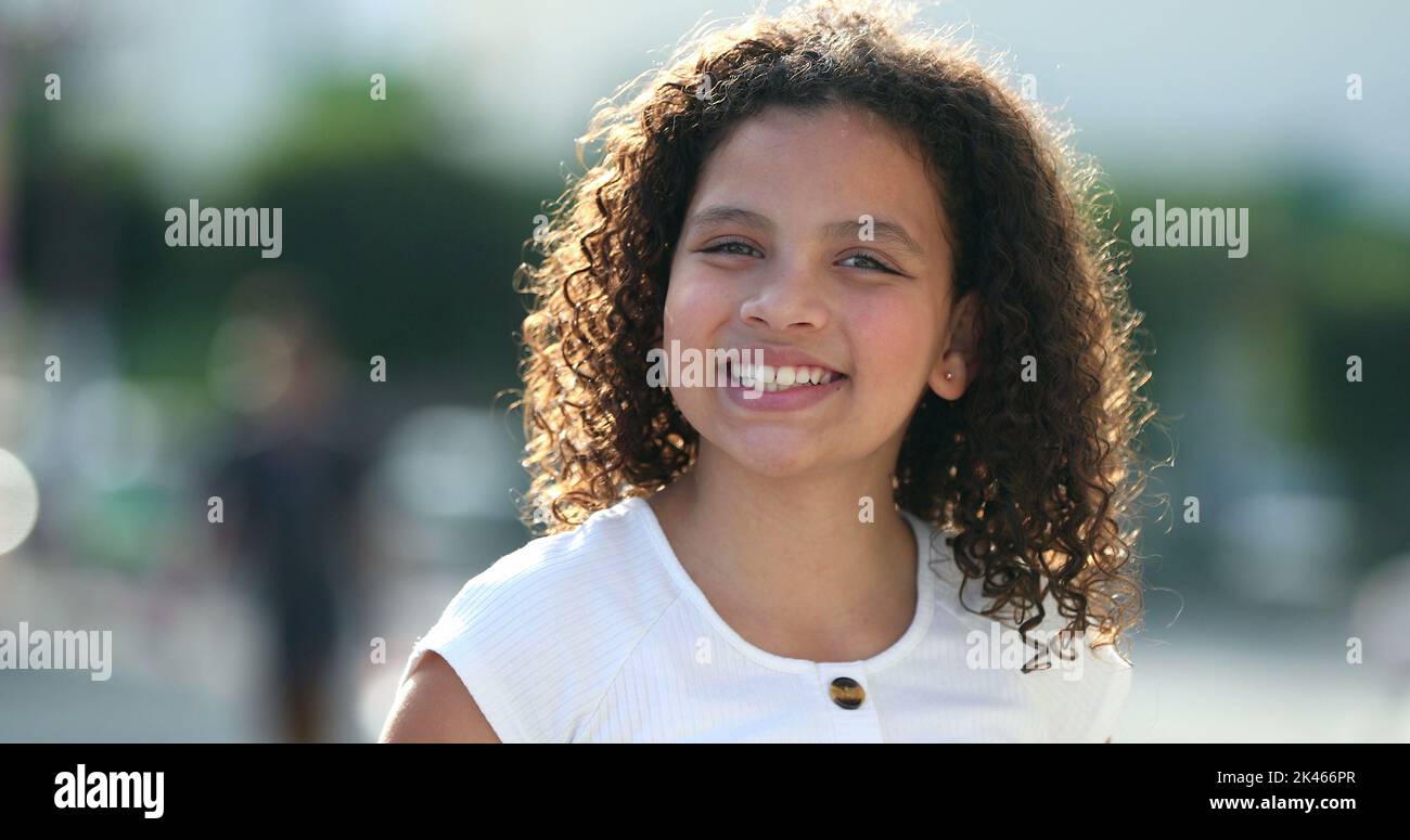 HIspanic little girl child portrait face close-up smiling outside2 Stock Photo - Alamy