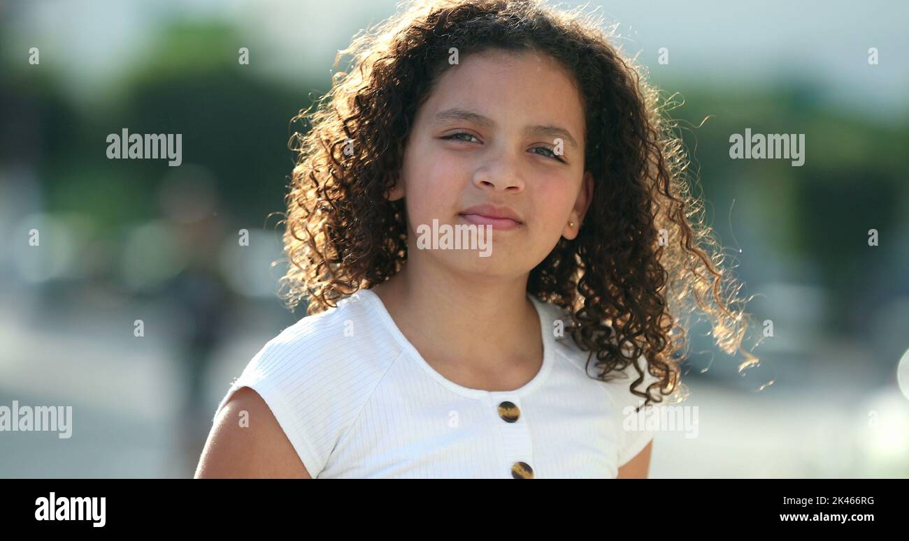 HIspanic little girl child portrait face close-up smiling outside2 Stock Photo - Alamy