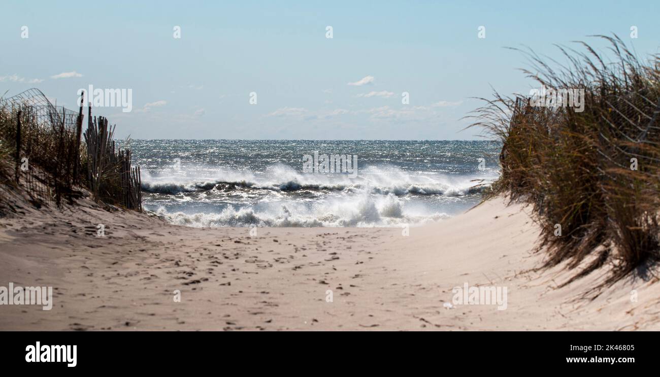 View of walking down the beach with alooking at a rough Atlantic Ocean ...