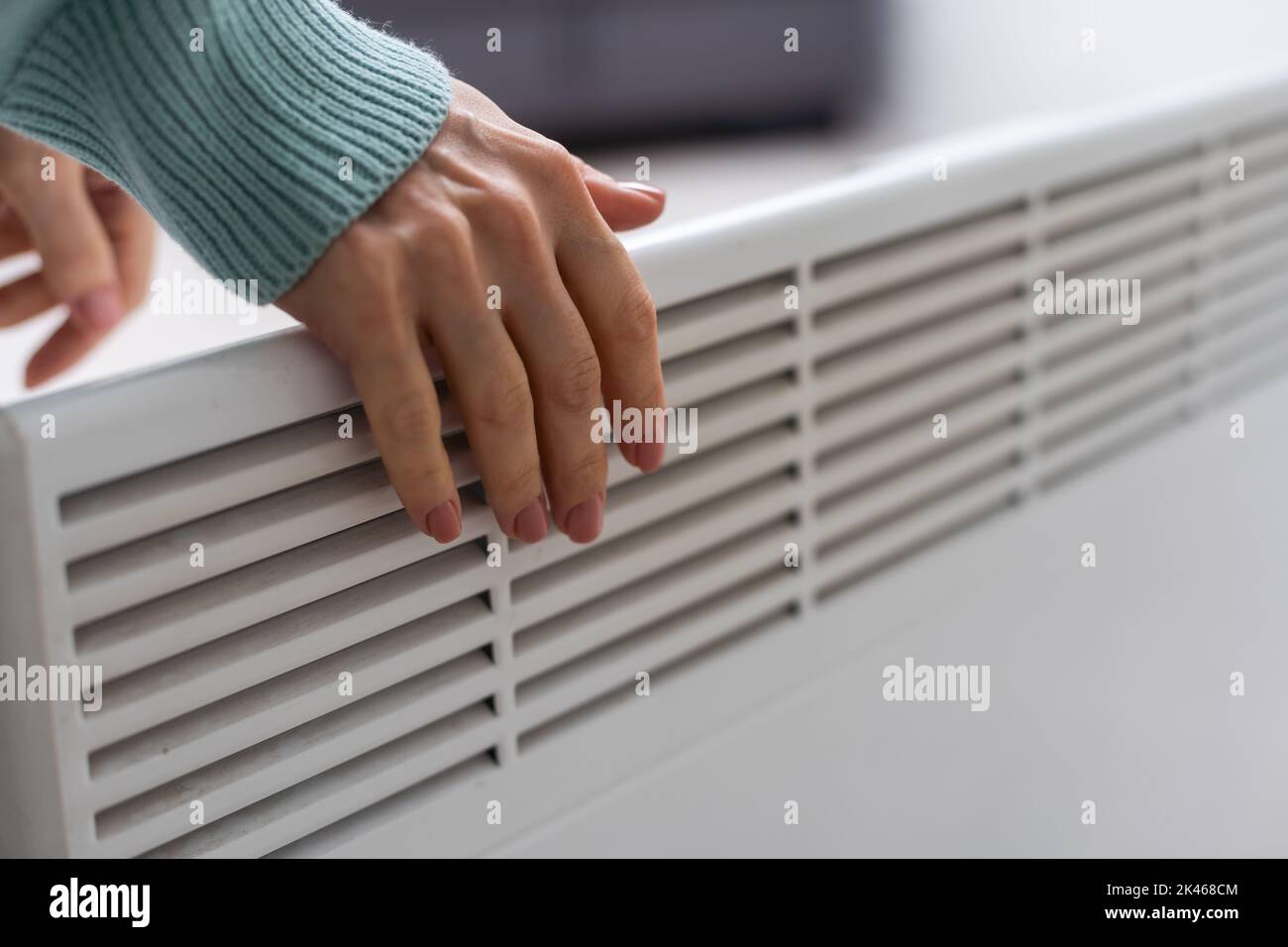 Woman's hand on a white radiator. Heating season. Energy crisis. Cold ...