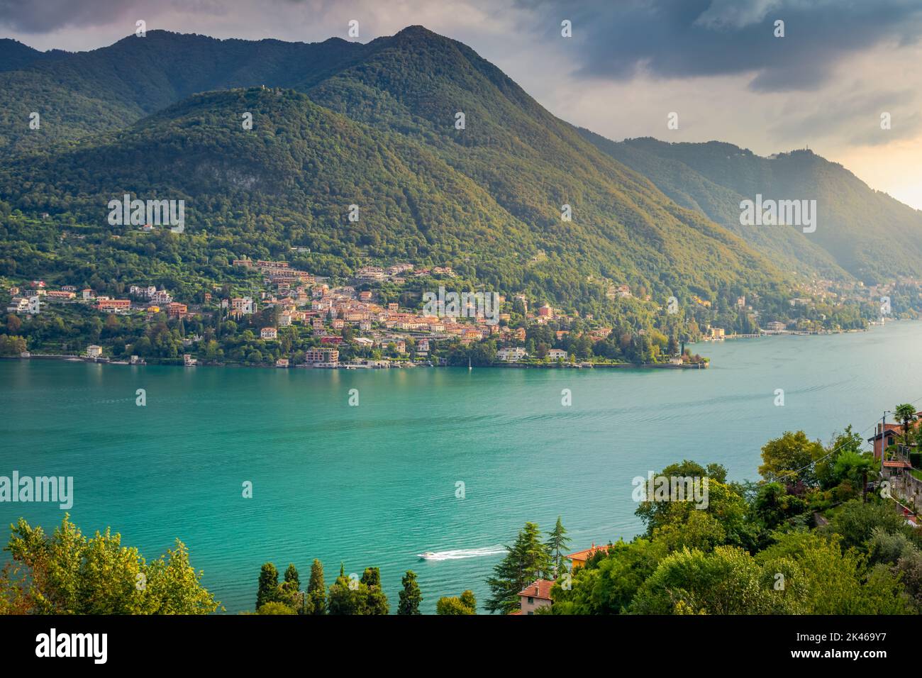 Idyllic Lake Como coastline with village and boat at sunset, Northern ...
