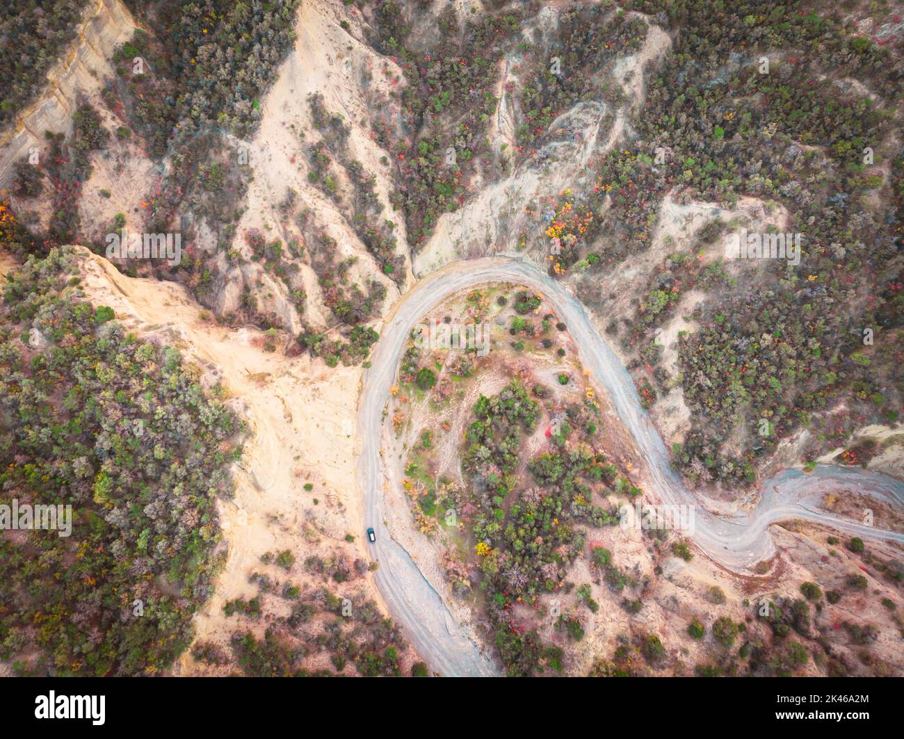 Birds eye Aerial view down to jeep driving on the road surrounded by ...