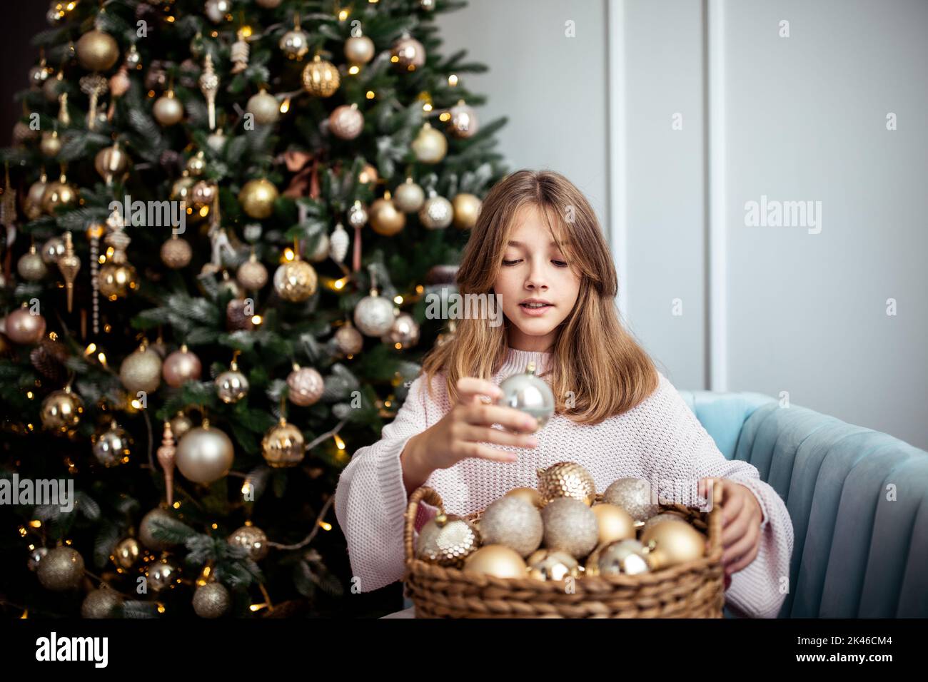 Cute teenage girl in a room with a decorated Christmas tree. The winter ...