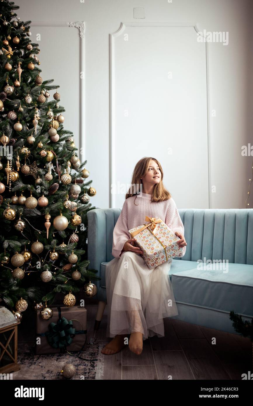Cute teenage girl in a room with a decorated Christmas tree. The winter ...