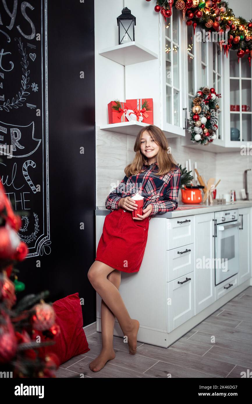 Cute teenage girl in the kitchen with Christmas decorations. The winter ...