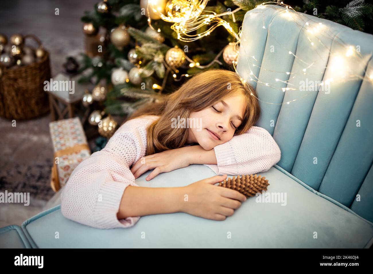 Cute teenage girl in a room with a decorated Christmas tree. The winter ...