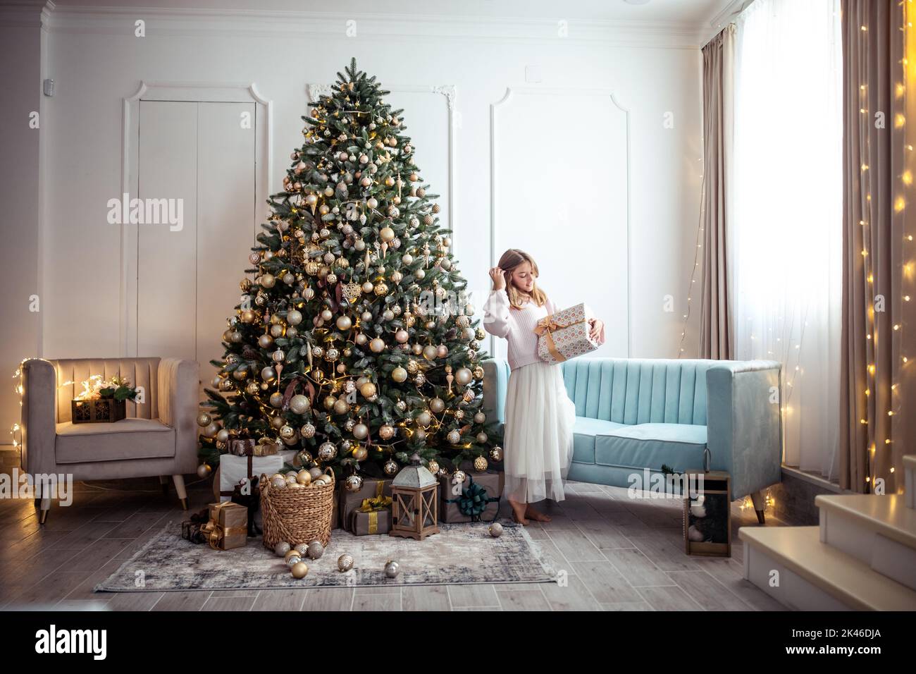 Cute teenage girl in a room with a decorated Christmas tree. The winter ...