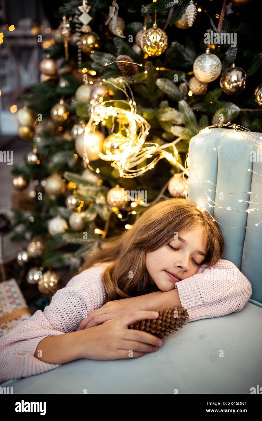 Cute teenage girl in a room with a decorated Christmas tree. The winter ...