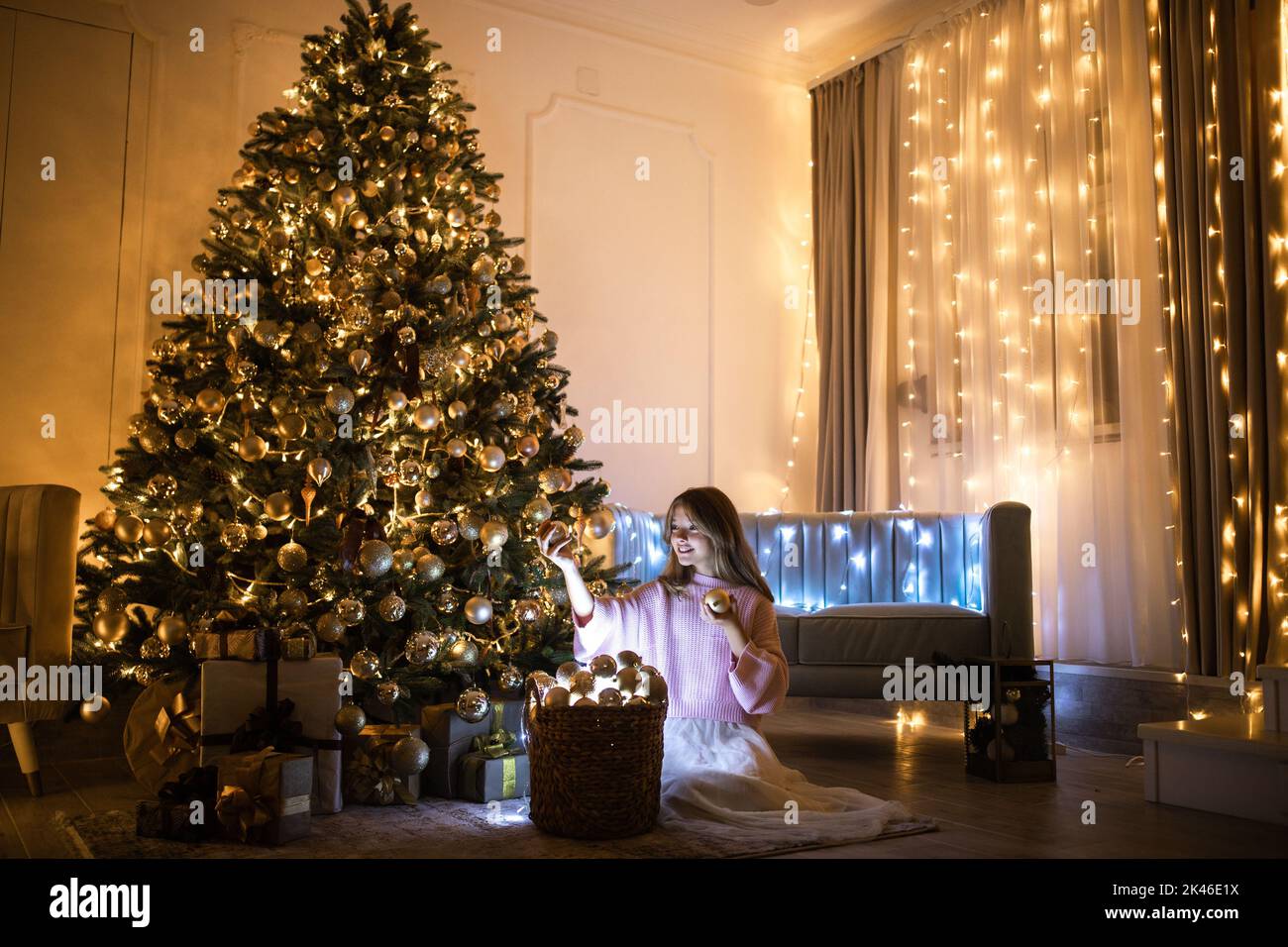 Cute teenage girl in a room with a decorated Christmas tree. The winter ...