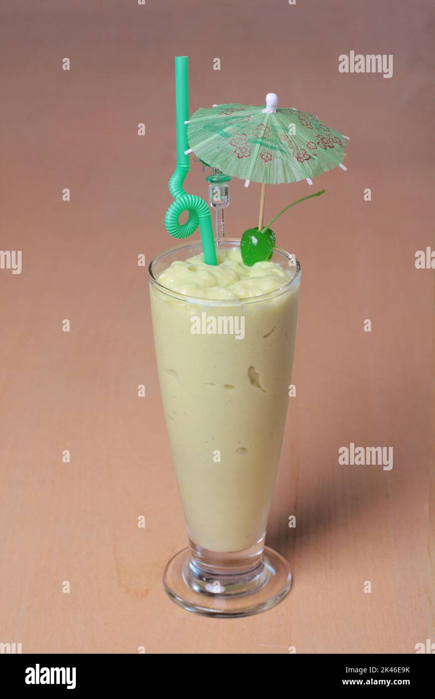 Glass of avocado smoothie or milkshake with fresh fruit classically ...