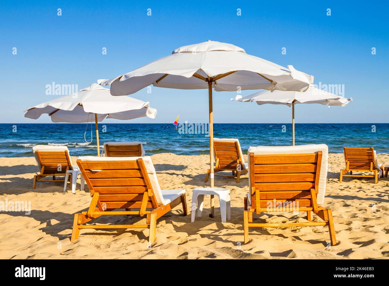 Coastal landscape - Beach umbrellas and loungers on the sandy seashore ...