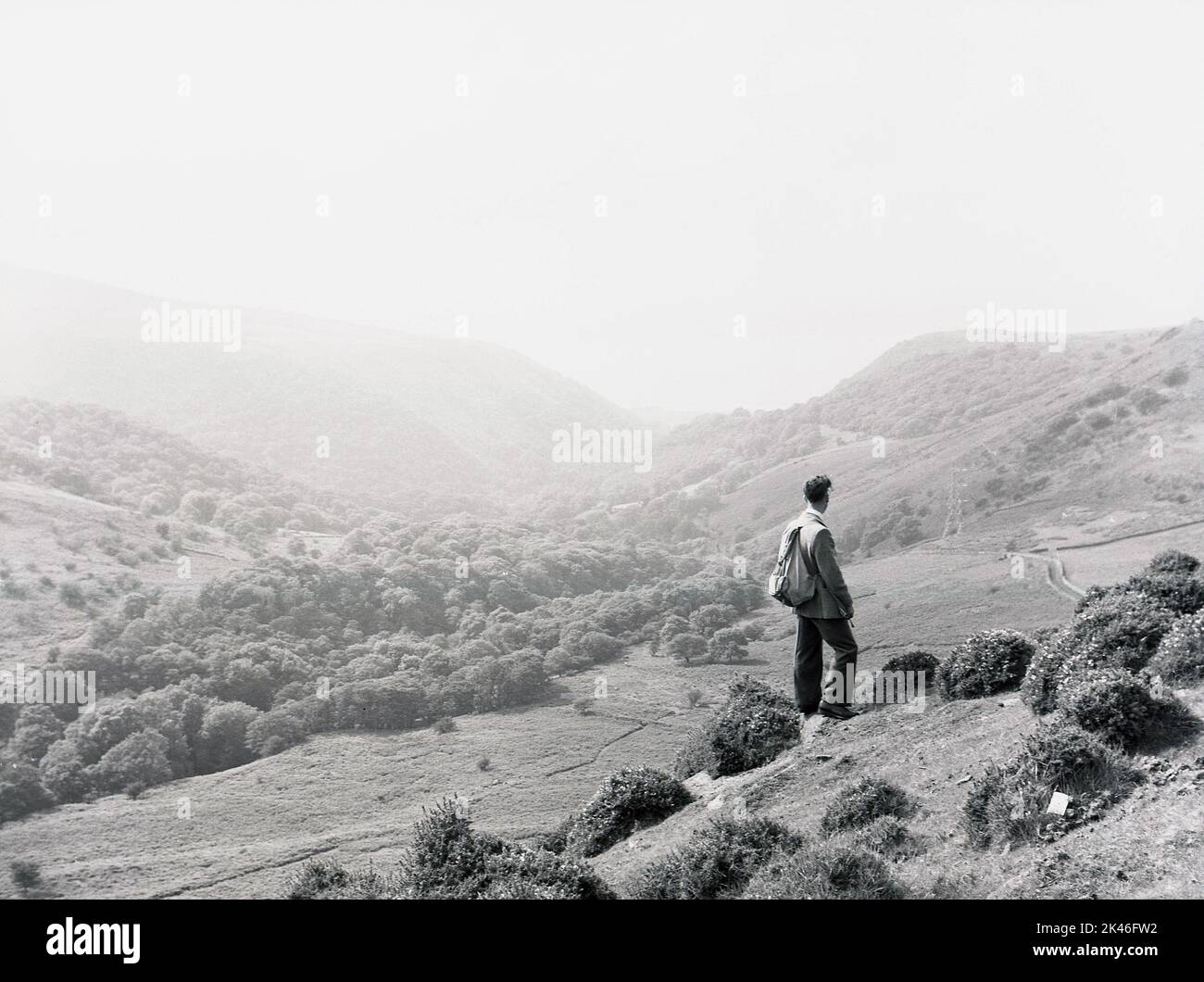 1956, historical, a walker with a canvas rucksack standing looking over ...