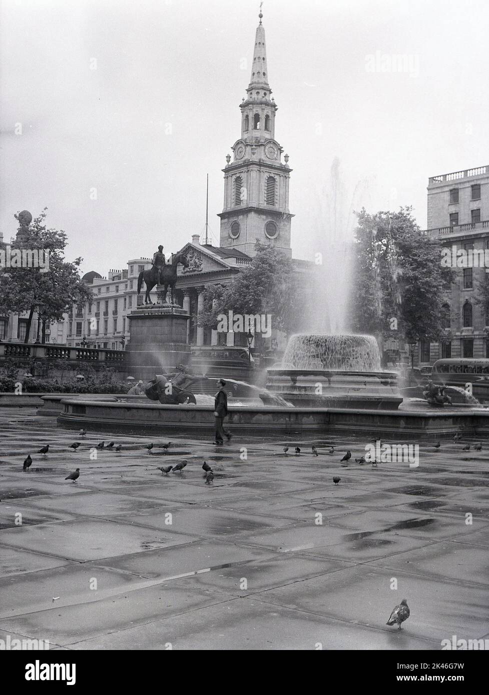 1958, historical, a man by a water fountain in a deserted Trafalgar ...