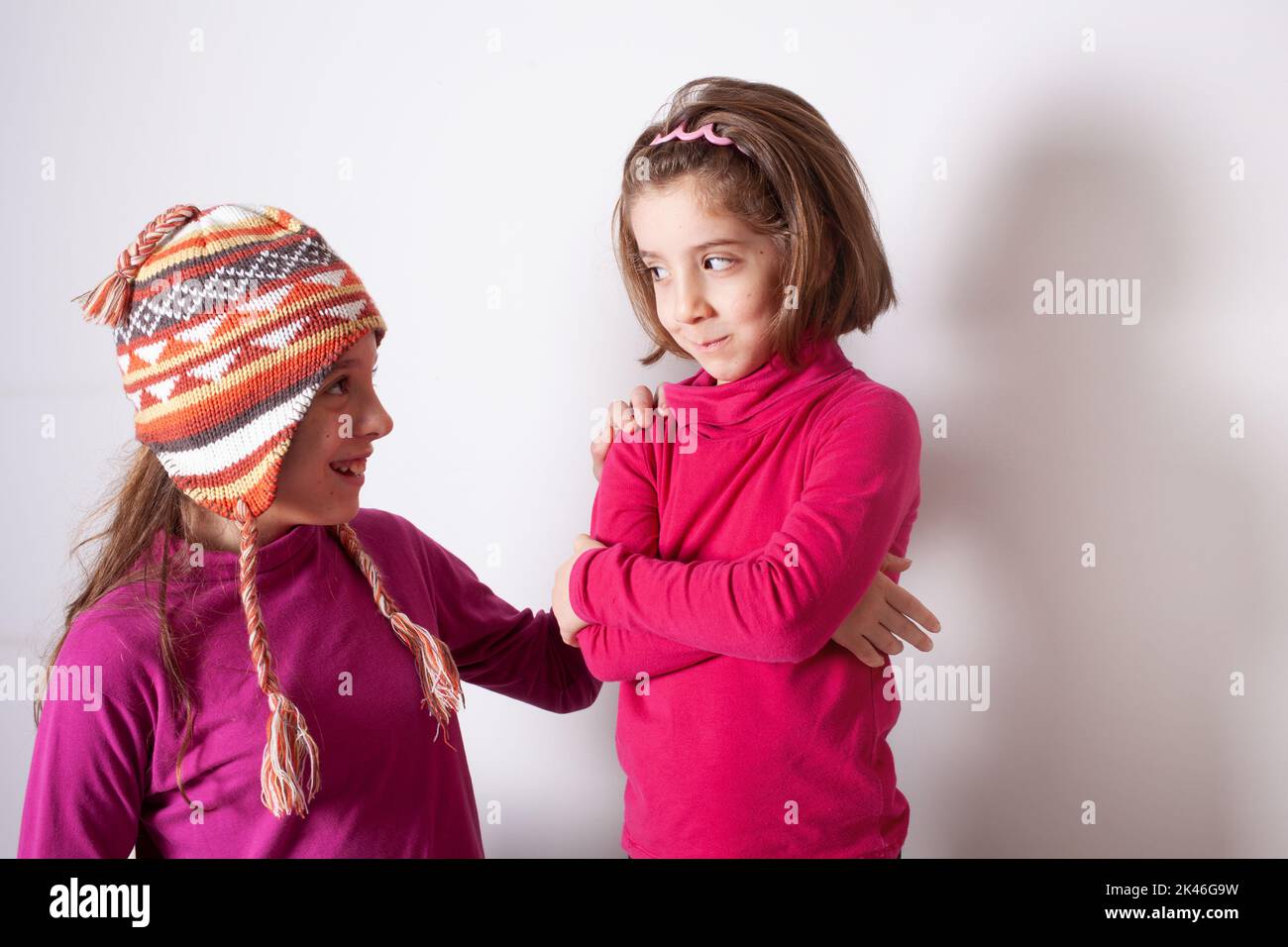 Loving little girl consoling her sad and sulky sister and trying to ...
