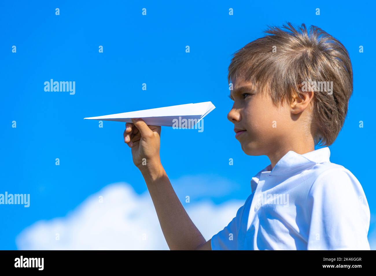 Child throwing white paper plane. Boy playing with paper airplane ...