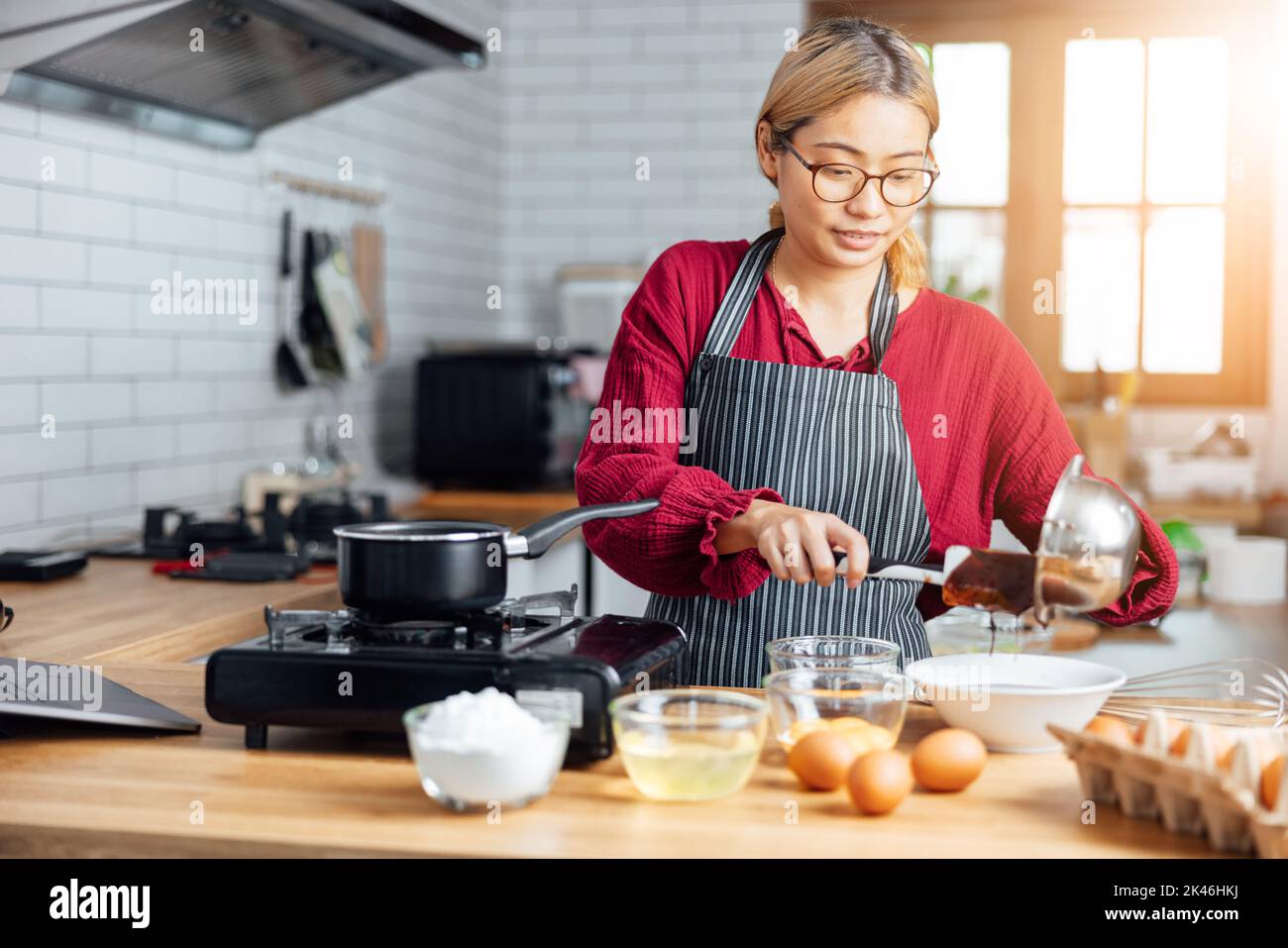 Beautiful Young Woman Is Mixing Batter Looking At Camera And Smiling While Baking In Kitchen At