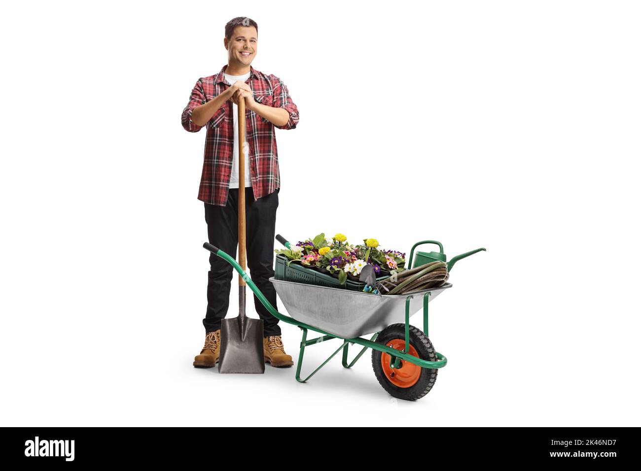 Full length portrait of a gardener with a shovel standing next to a ...