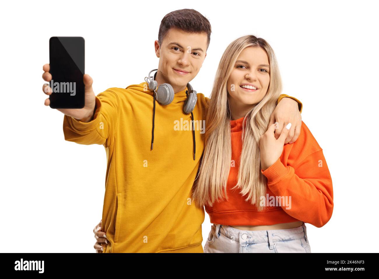Young man and woman in embarace showing a smartphone and smiling ...