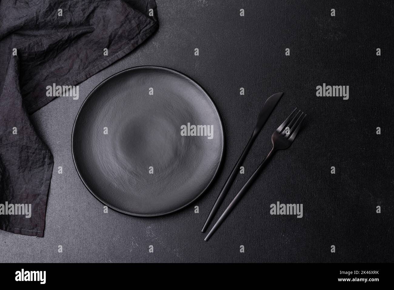 Black cutlery on a concrete dark table. Dining table preparation Stock ...