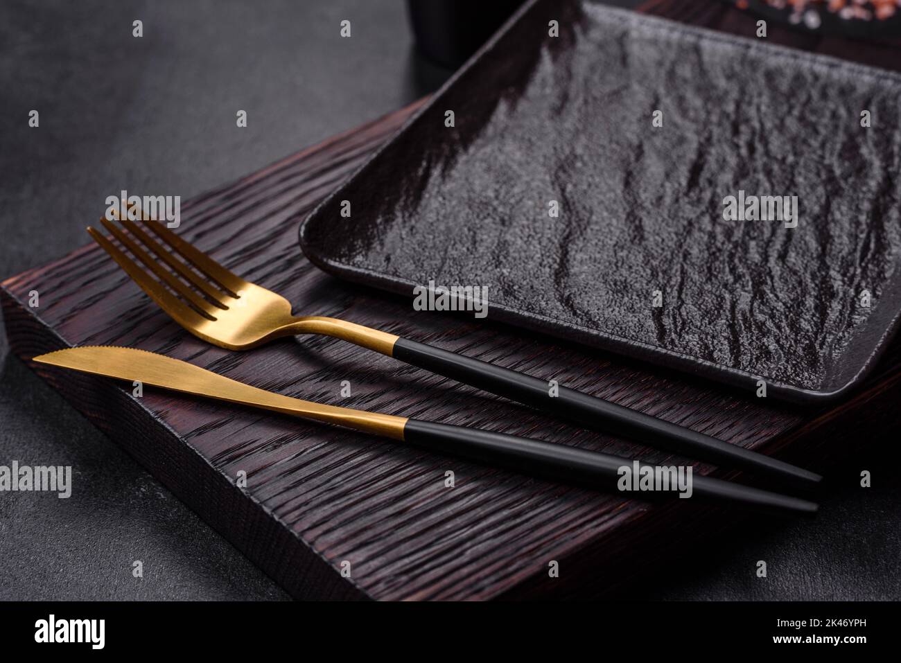 Black cutlery on a concrete dark table. Dining table preparation Stock ...