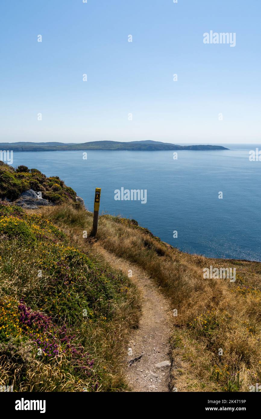 narrow hiking trail and trail marker leading along the ridge of the ...