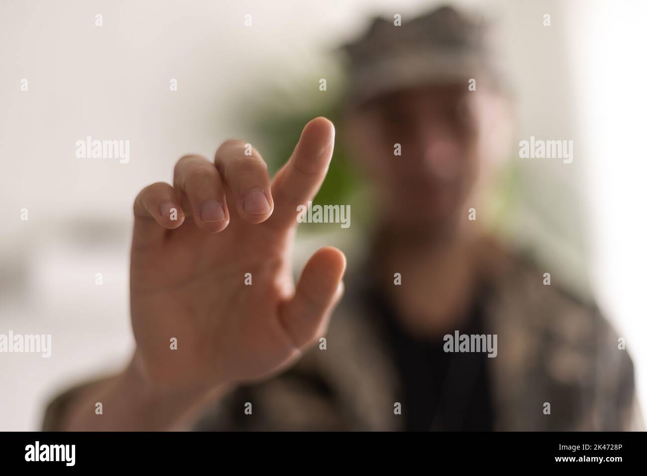 Soldier man isolated on white background pointing back with the index ...