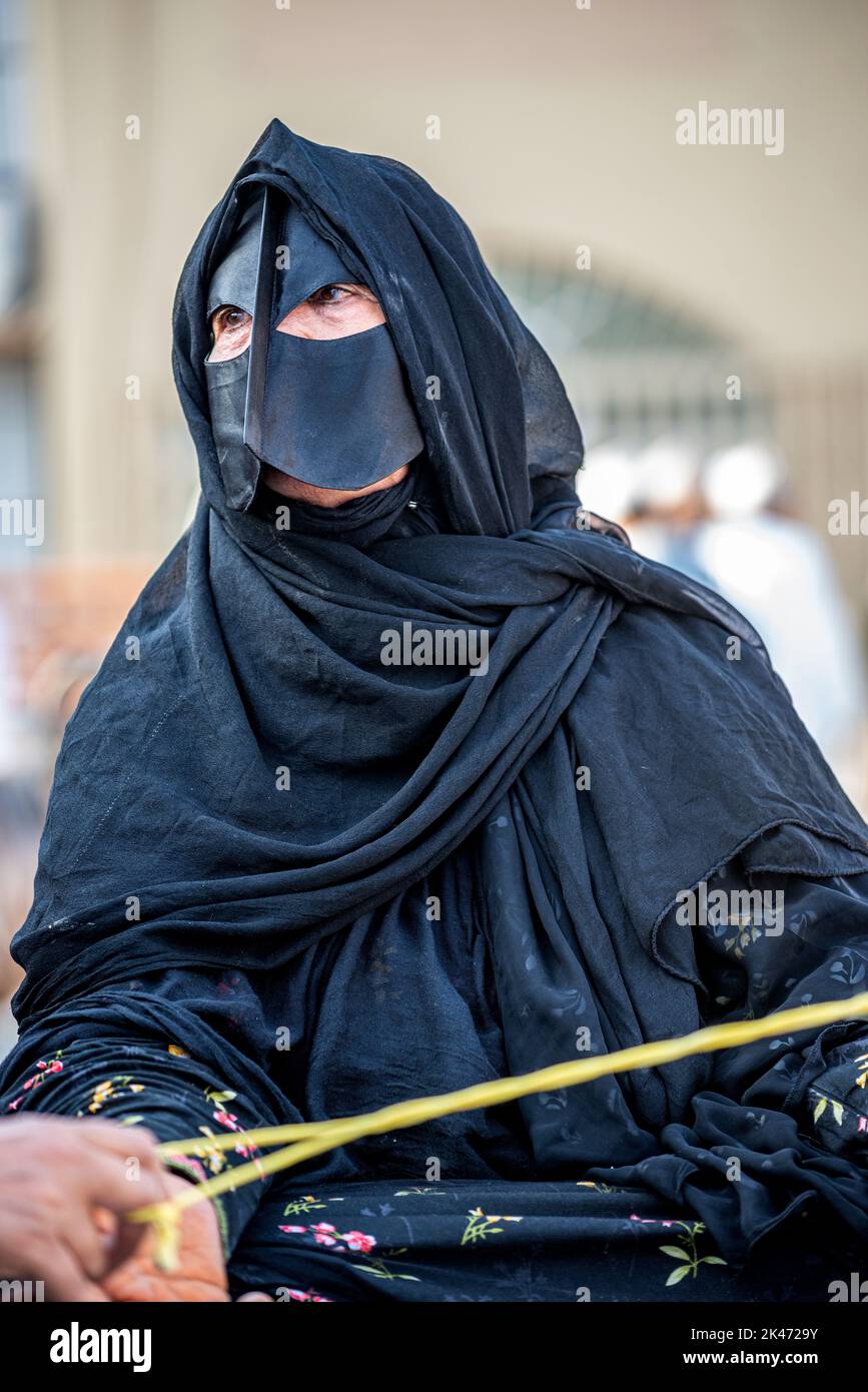 Woman with black "battoulah" (face mask) at friday morning cattle ...